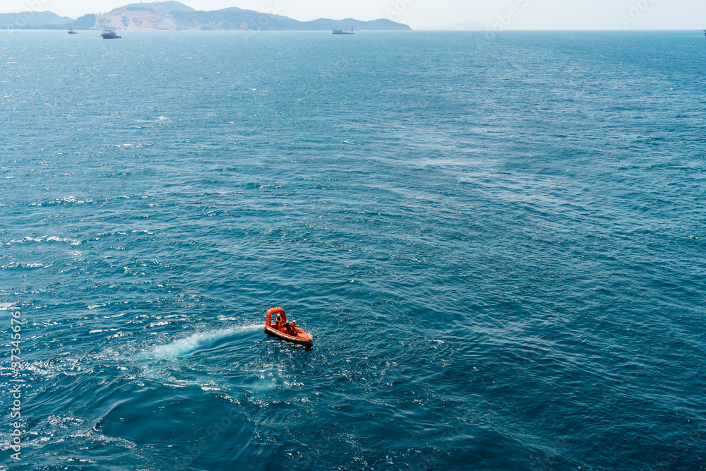 Marine crews of a pipelay barge maneuvering a light rescue craft or ...