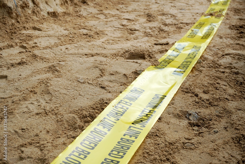 Underground warning tape placed on the sand to alert the underground ...