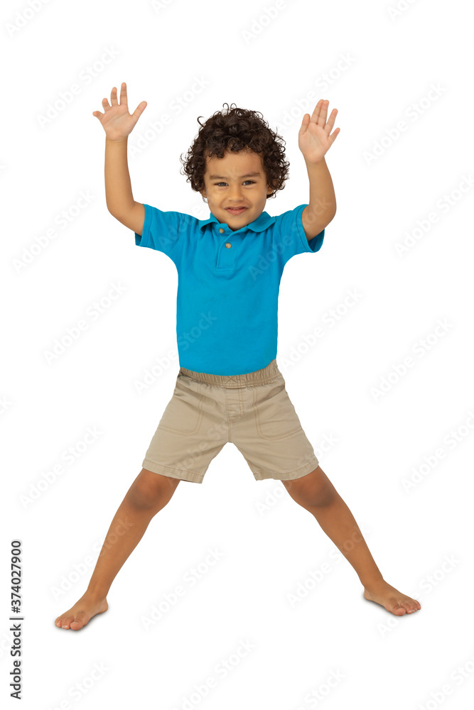 The happy boy spreads his legs and raises his arms high while he smiles ...