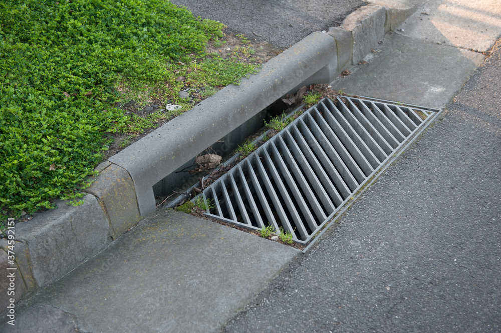 Gutter of a stormwater drainage system in perspective on the side of an ...