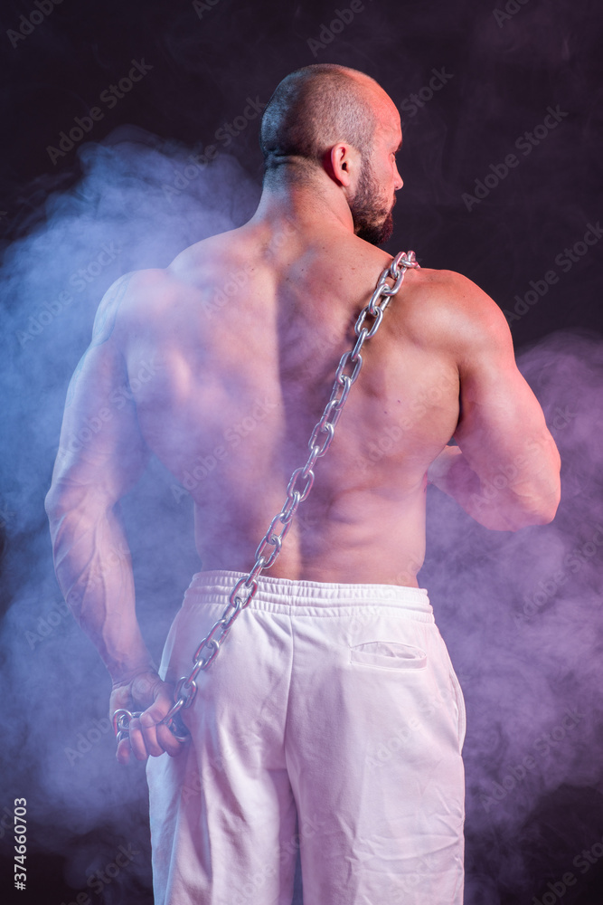 Powerful muscular man shirtless posing with chain. Studio shoot with ...