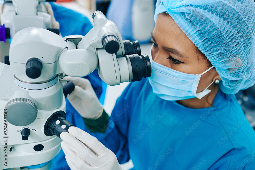 Professional ophthalmic surgeon using modern equipment when performing ...