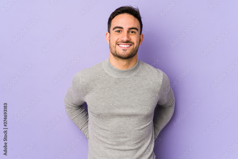Young caucasian man isolated on purple background happy, smiling and ...