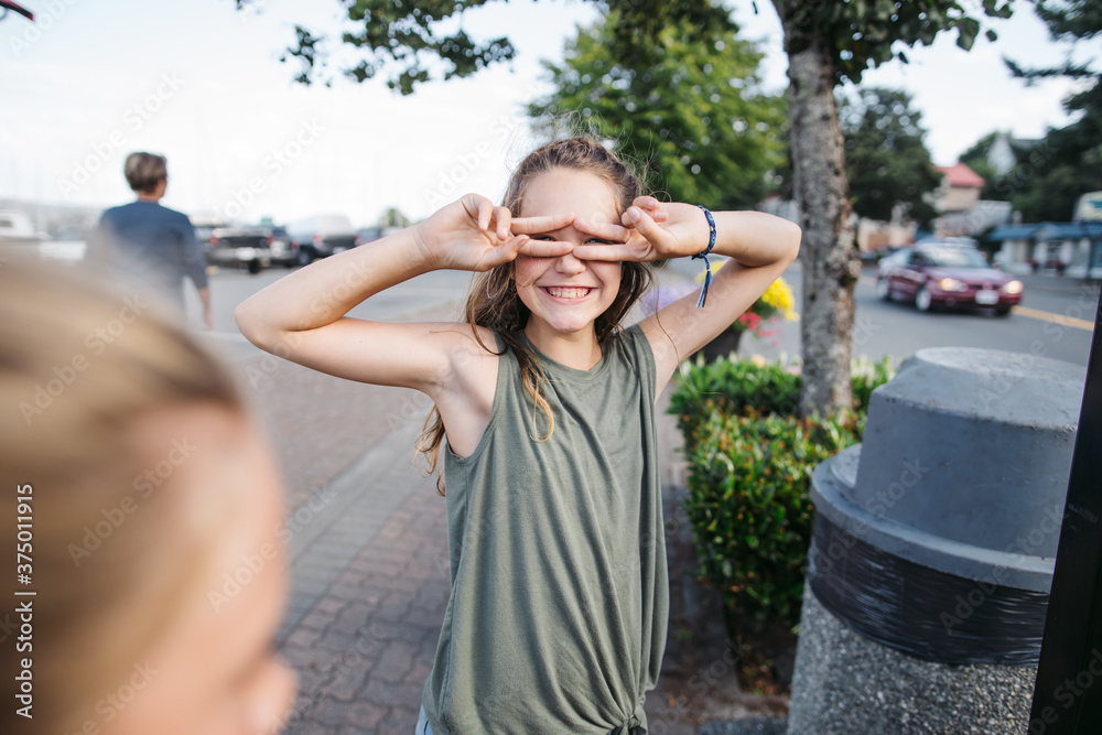 Goofy pre teen girl doing peace signs Stock Photo | Adobe Stock