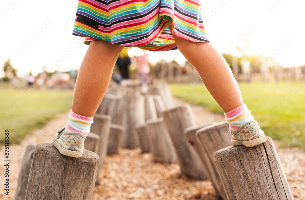 Child does balance exercise on wooden pegs. Little girl balances on ...