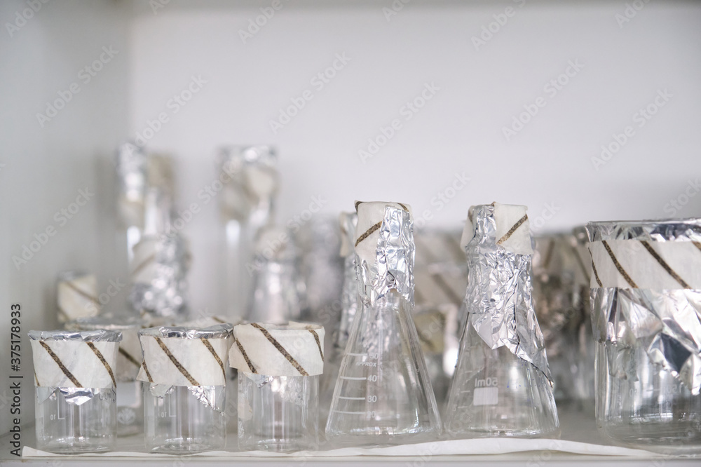 Sterile laboratory glassware with aluminum foil and autoclave tape ...