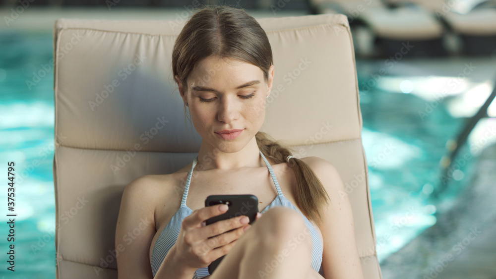 Portrait of sexy woman relaxing with phone by pool. Pretty girl scrolling mobile Stock Photo ...