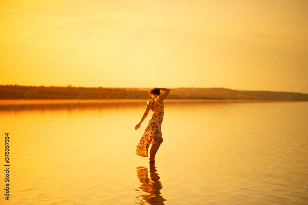 Faceless portrait of silhouette of young woman dancing on beach at ...