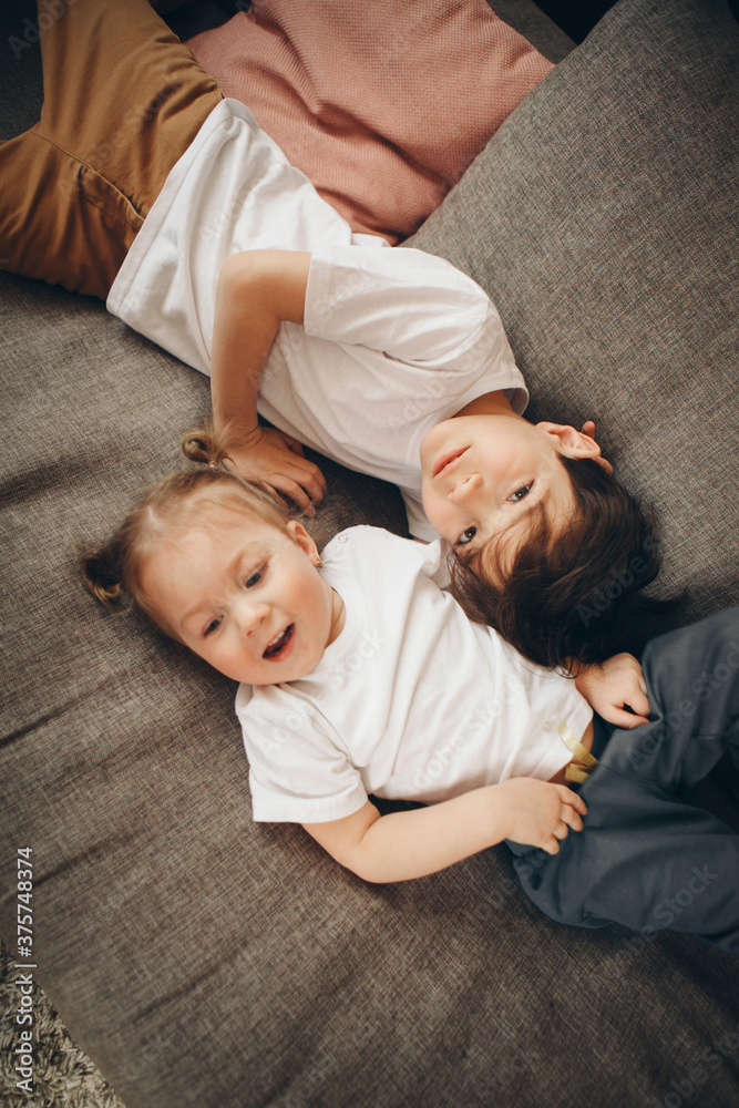 children playing together. Happy kids: brother and sister lying on the ...