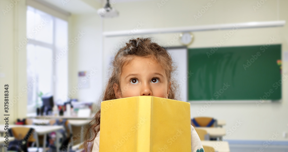 school, education and childhood concept - little girl hiding behind ...