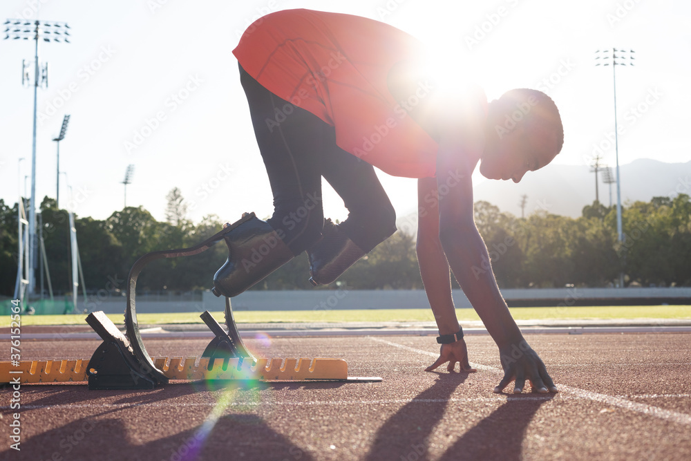 Black African American Male athlete with prosthetic legs bending on ...
