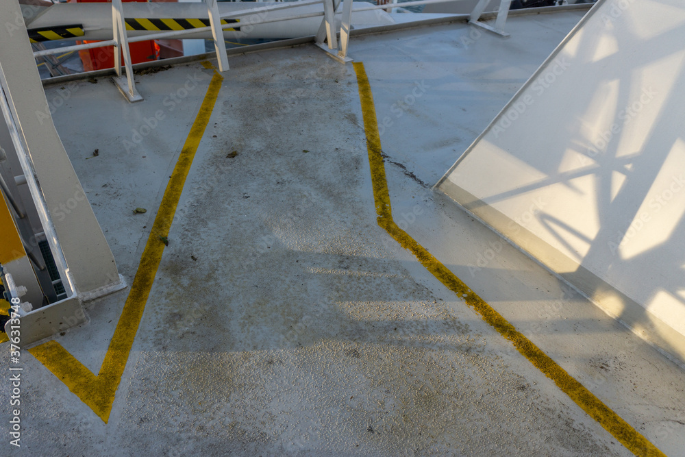 Stock-Foto „Safety walkway on ships deck. Yellow line walkway. Guided ...