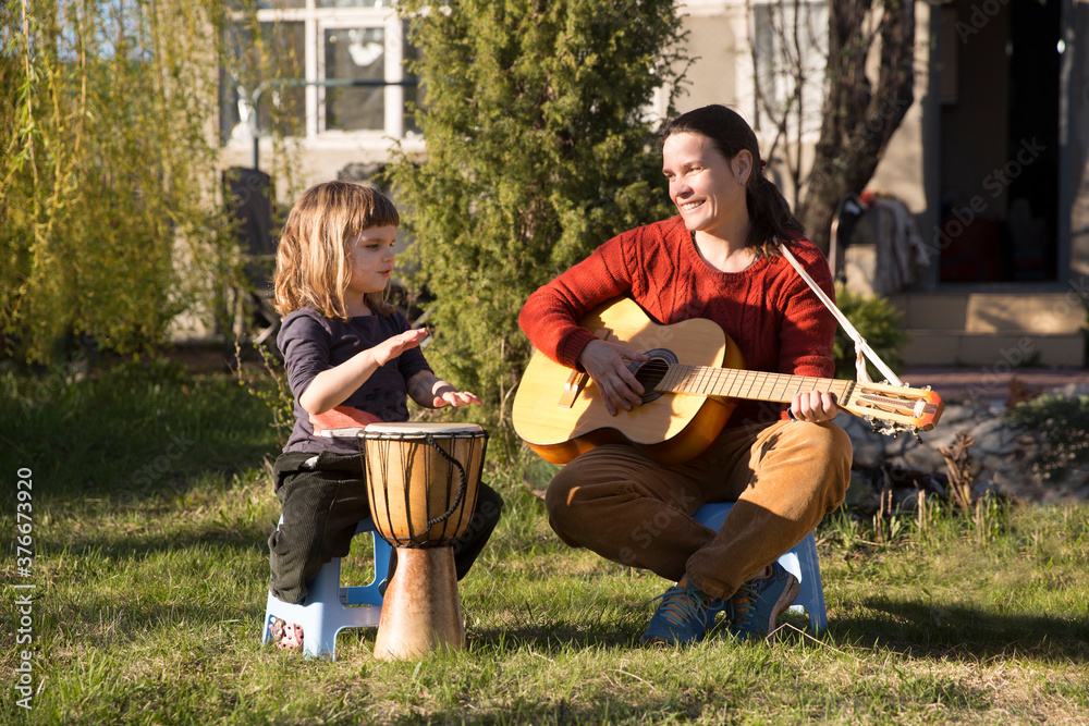 Happy family mom and child daughter having fun with musical instruments ...