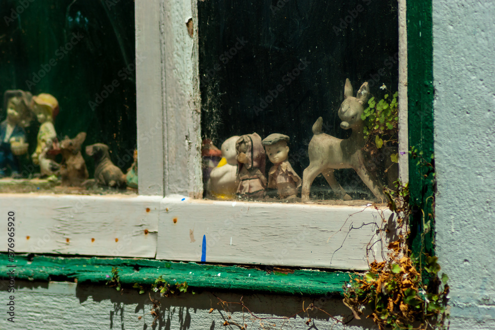 Through an old window, you can see several toys, including a donkey and ...