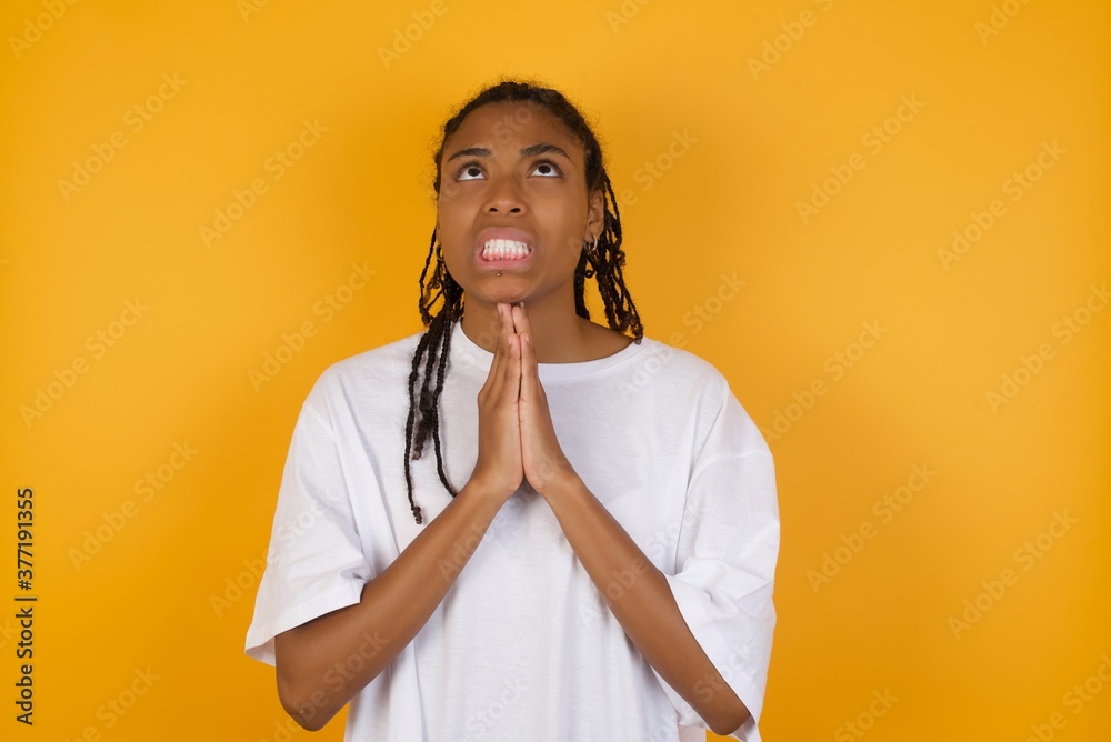 Young dark skinned woman with braids hair wearing white t-shirt over ...