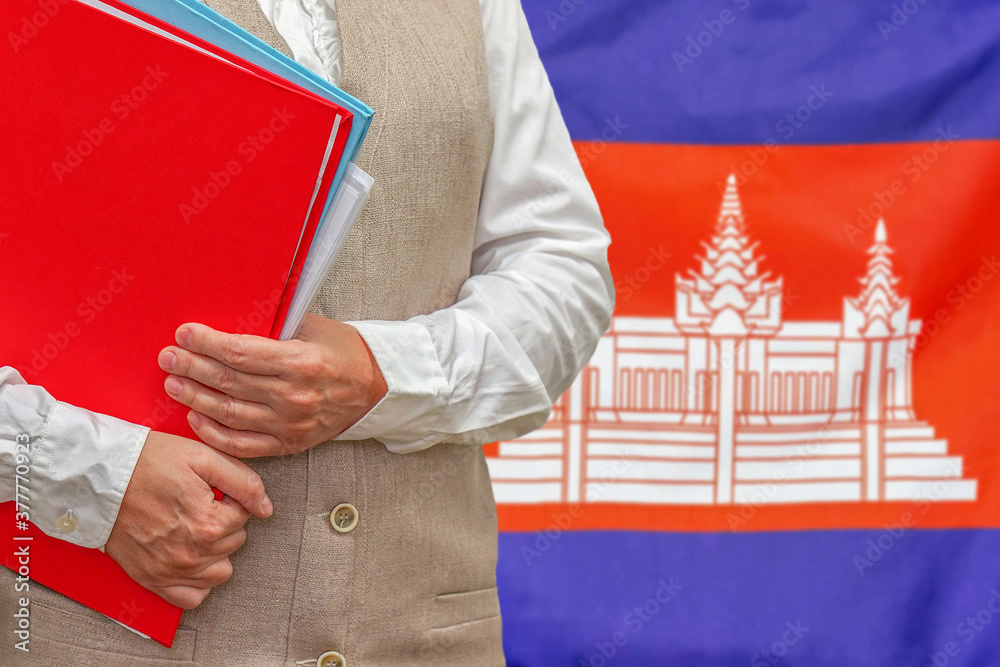 Woman holding red folder on Cambodia flag background. Education and ...