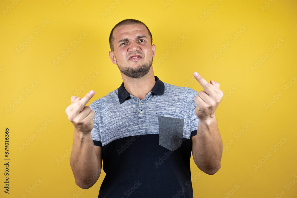 Russian man standing over insolated yellow background showing middle ...