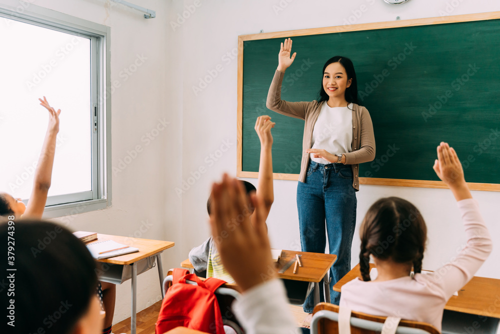 Photo Stock Asian school teacher with students raising hands. Young ...