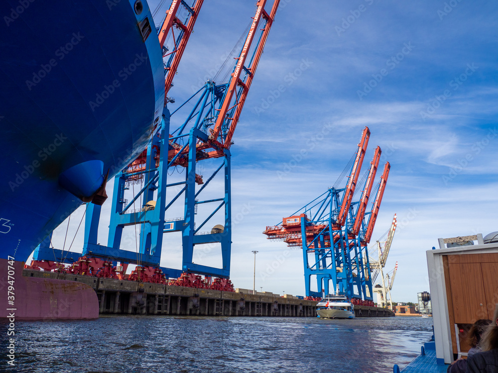 next to a container ship there are large container cranes for loading ...