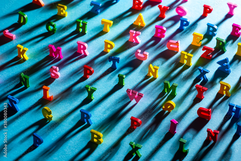 Letters of alphabet are randomly placed. Multicolored letters on a blue ...