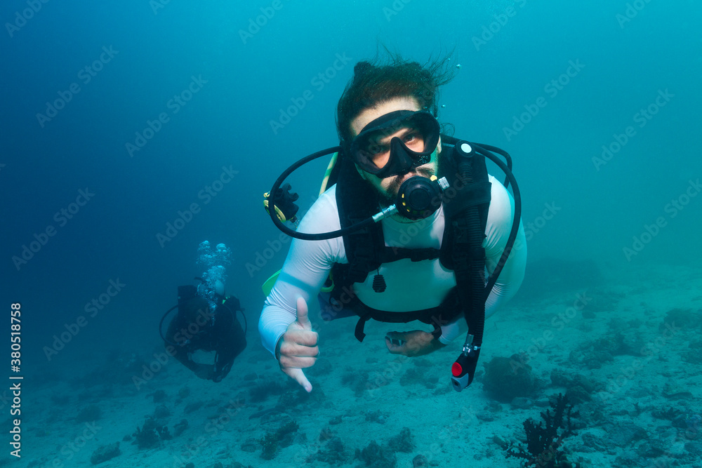 Scuba diver showing hang loose sign underwater Stock Photo | Adobe Stock