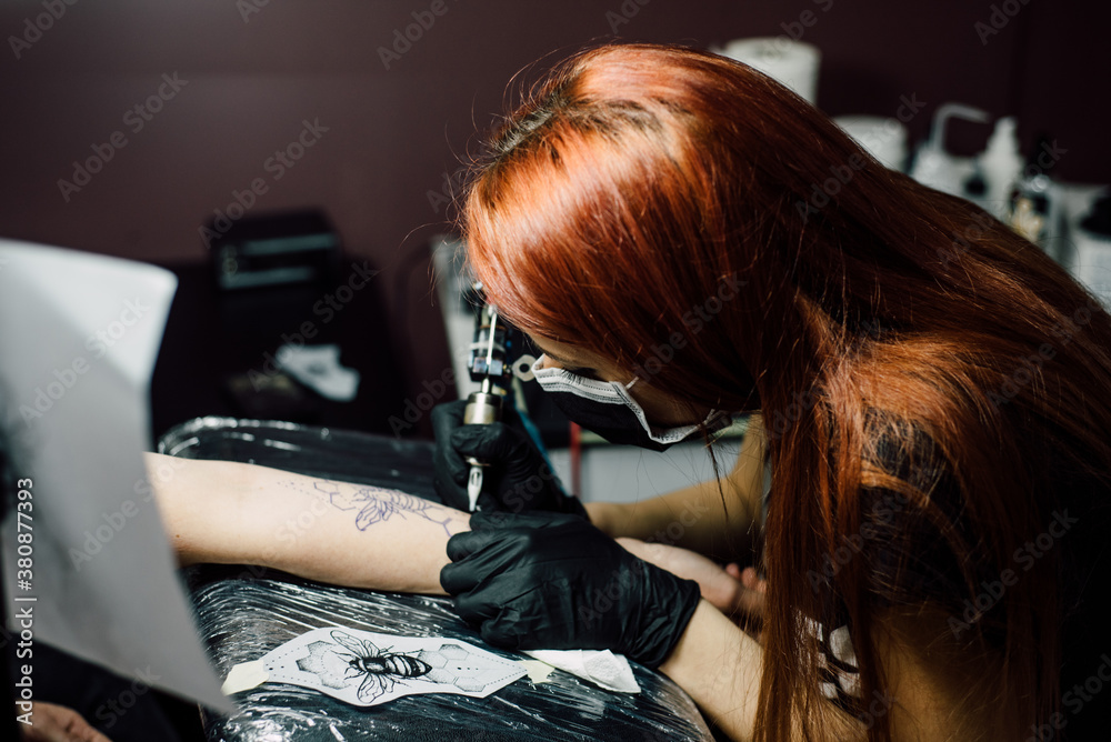 Tattoo artist working on a tattoo Stock Photo | Adobe Stock