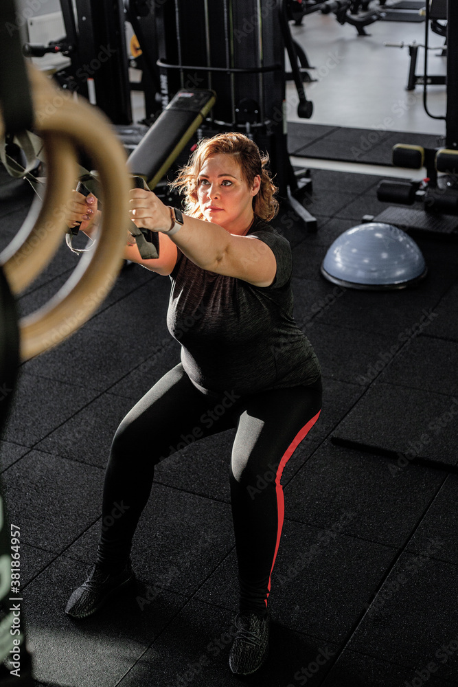 Foto de Stock Fat woman fights overweight in the gym, doing heavy fitness exercises for future ...