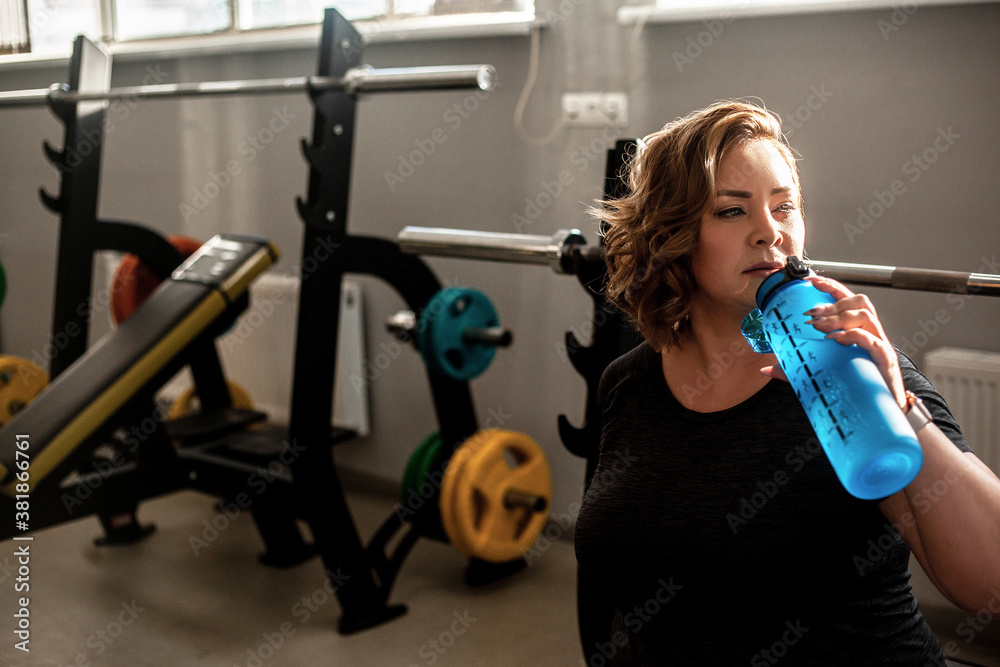 Fat woman fights overweight in the gym, doing heavy fitness exercises ...
