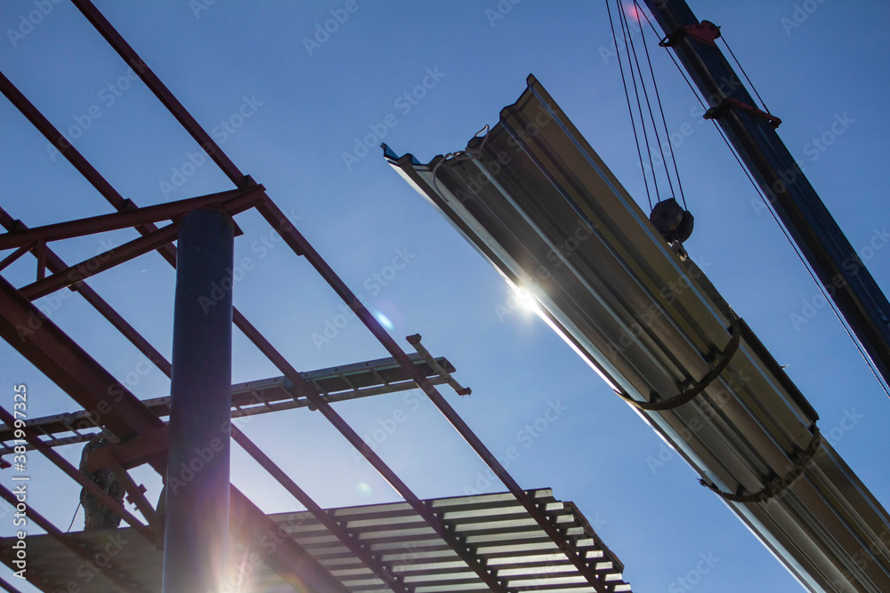 ภาพถ่าย Stock Mobile crane lifting metal roof sheet on palate truss up ...