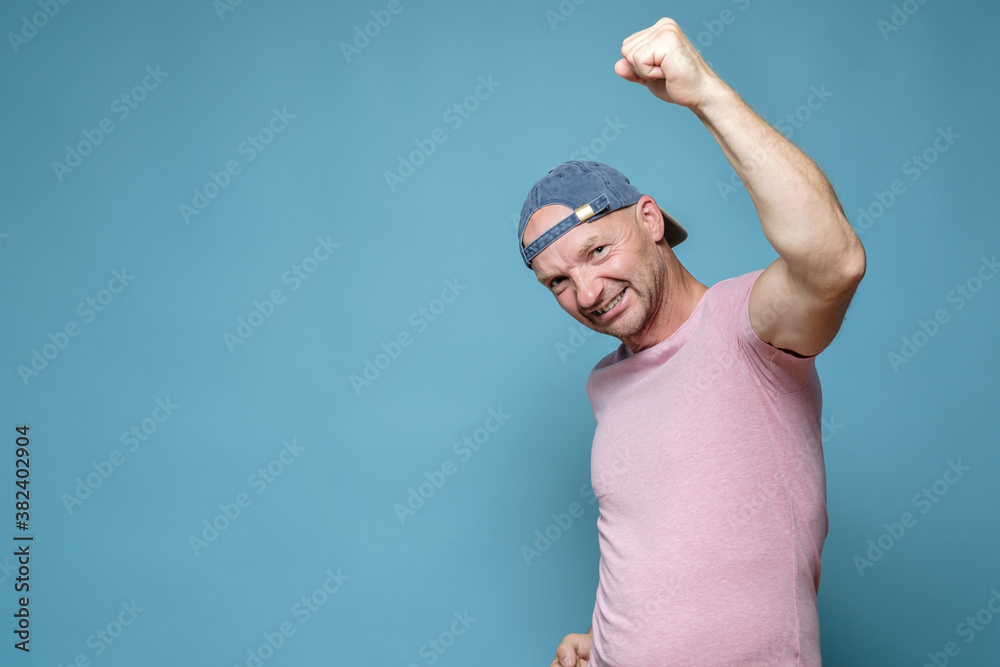 Confident, strong man makes a winner gesture raising hand with a ...