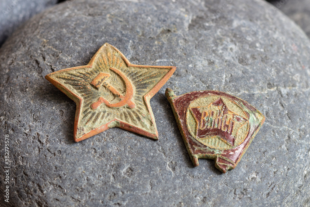 A red star from a military cap and a Komsomol badge, along with casings ...