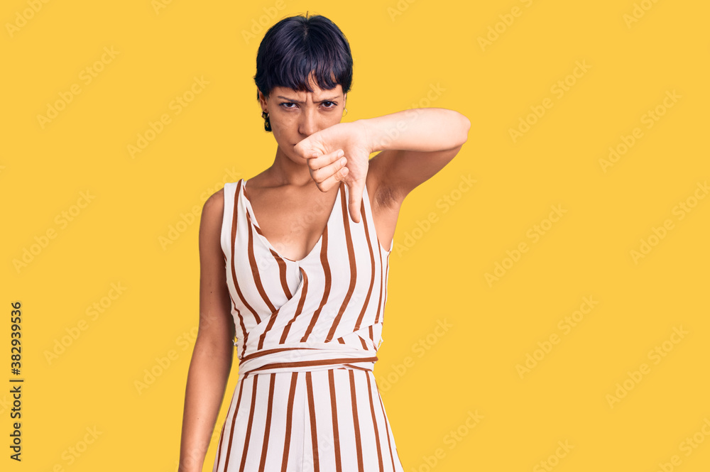 Young brunette woman with short hair wearing summer outfit looking ...