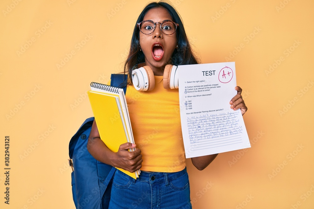 Young indian girl wearing backpack showing a passed exam afraid and ...