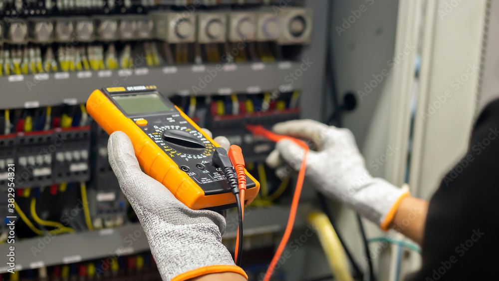 Electrician engineer uses a multimeter to test the electrical ...