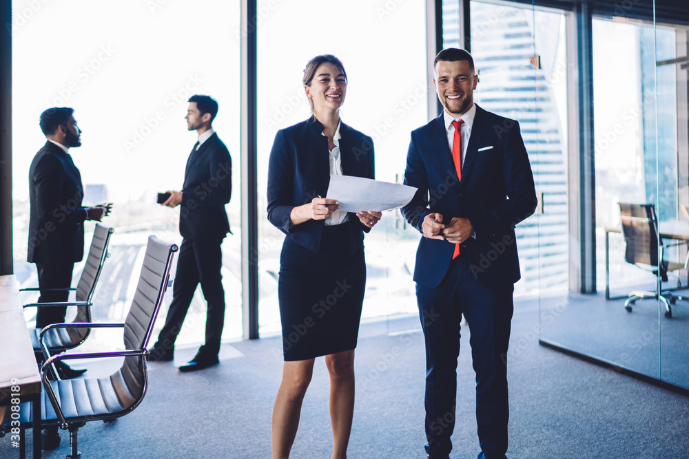 Portrait of cheerful male and female colleagues in formal suits posing ...