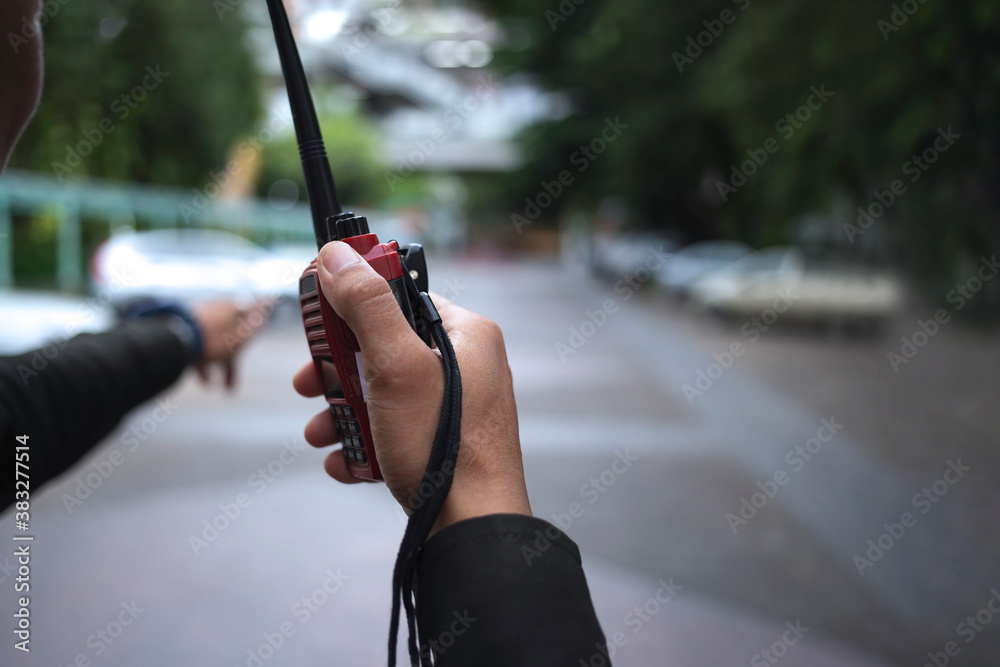 Security guard uses radio communication for facilitate traffic. Traffic ...