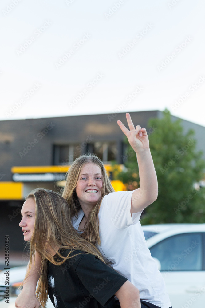 Two teenage girls,one making peace sign Stock Photo | Adobe Stock