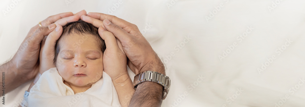 Close up father and mother hands holding newborn baby, copy space ...