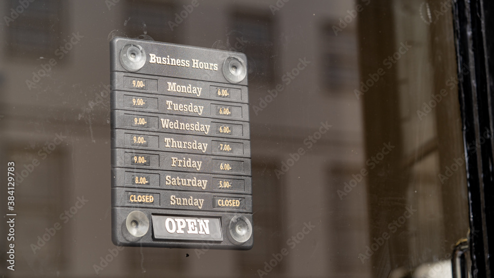 Opening times sign in a shop window Stock Photo | Adobe Stock