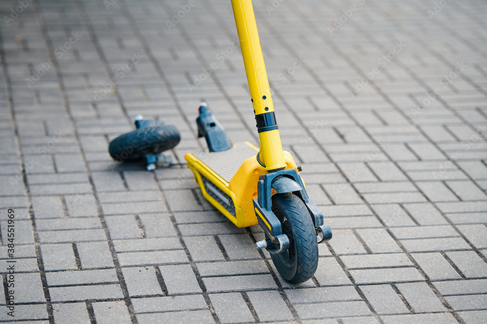 Broken electric rent scooter on city street. Torn off rear wheel ...
