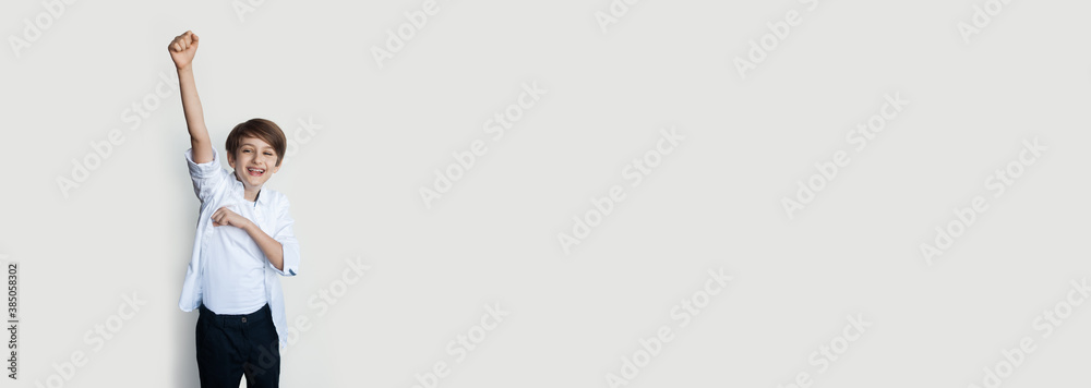 Caucasian boy gesturing the yes sign on a white studio wall with free ...