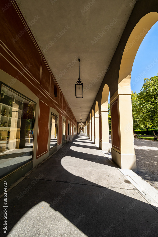 Promenade with long arcade columns surrounding Hofgarten Park in Munich ...