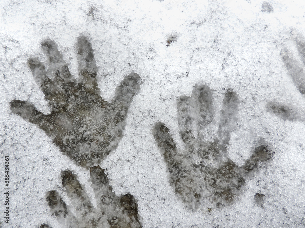 child hand prints in the snow. The impact of human heat on snow. A ...