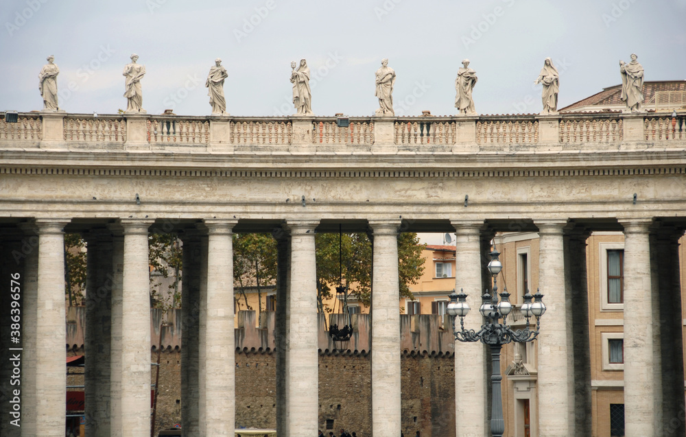 The famous colonnade of St. Peter's Square with statues in the Vatican ...