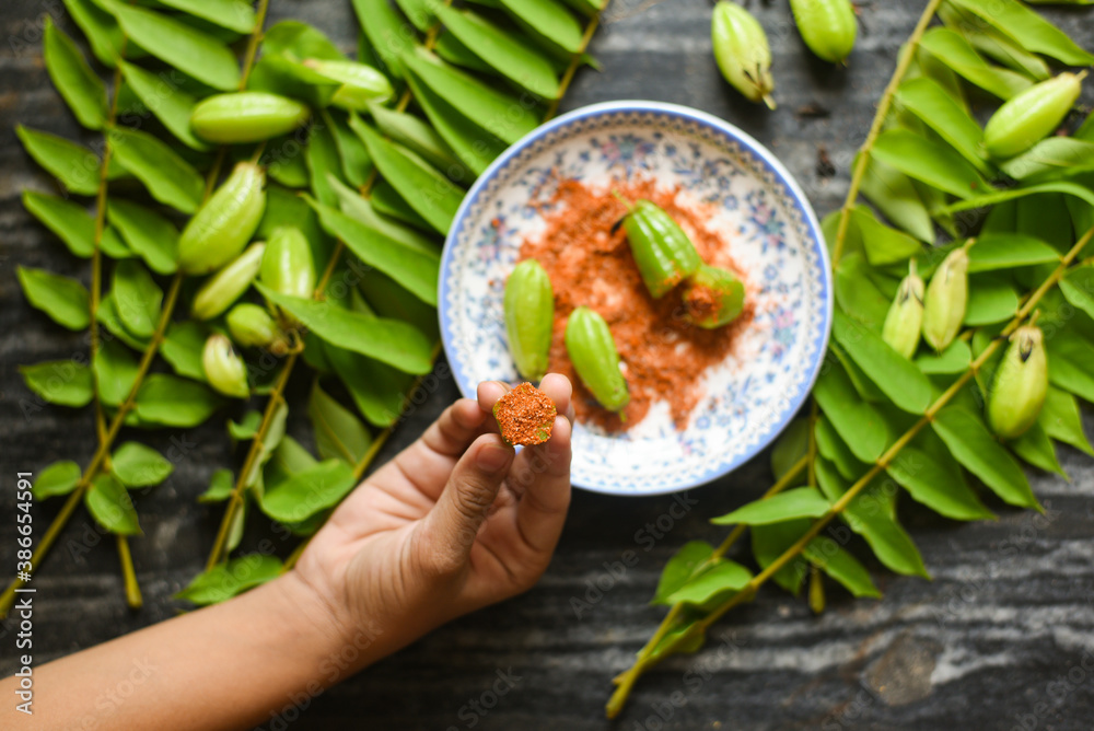 Girl taking Belimbing sayur , Averrhoa bilimbi fruit with chilli powder ...