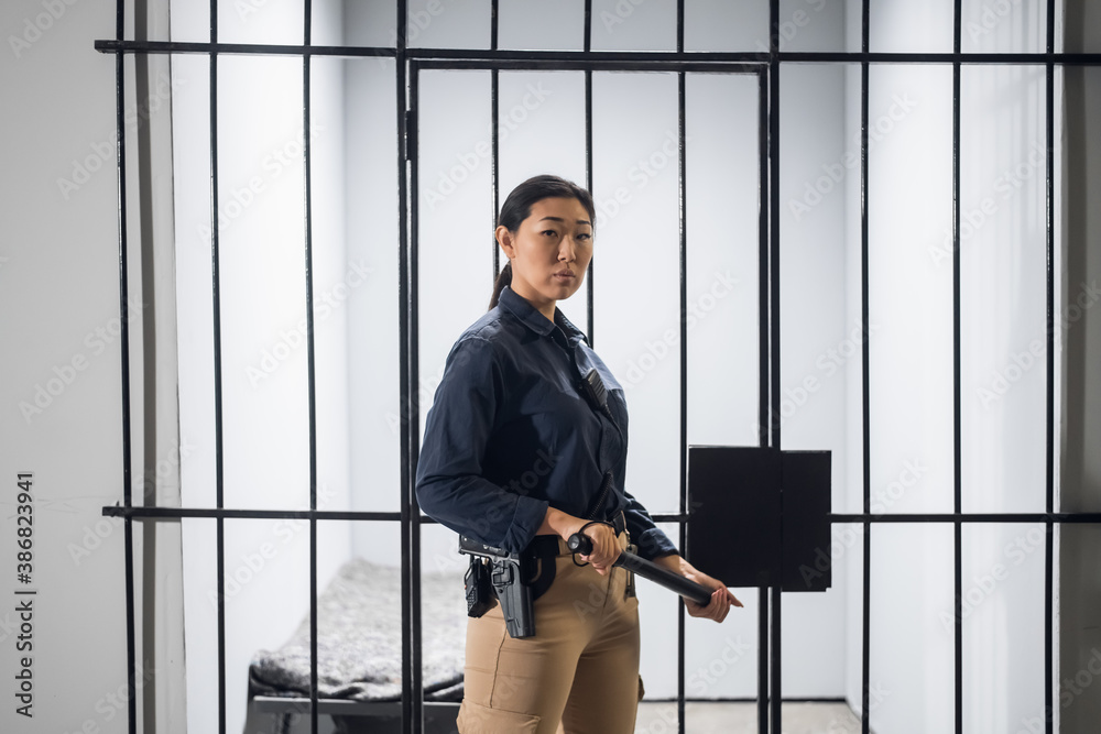 Asian guard in uniform In full armor with a baton and a pistol on the ...