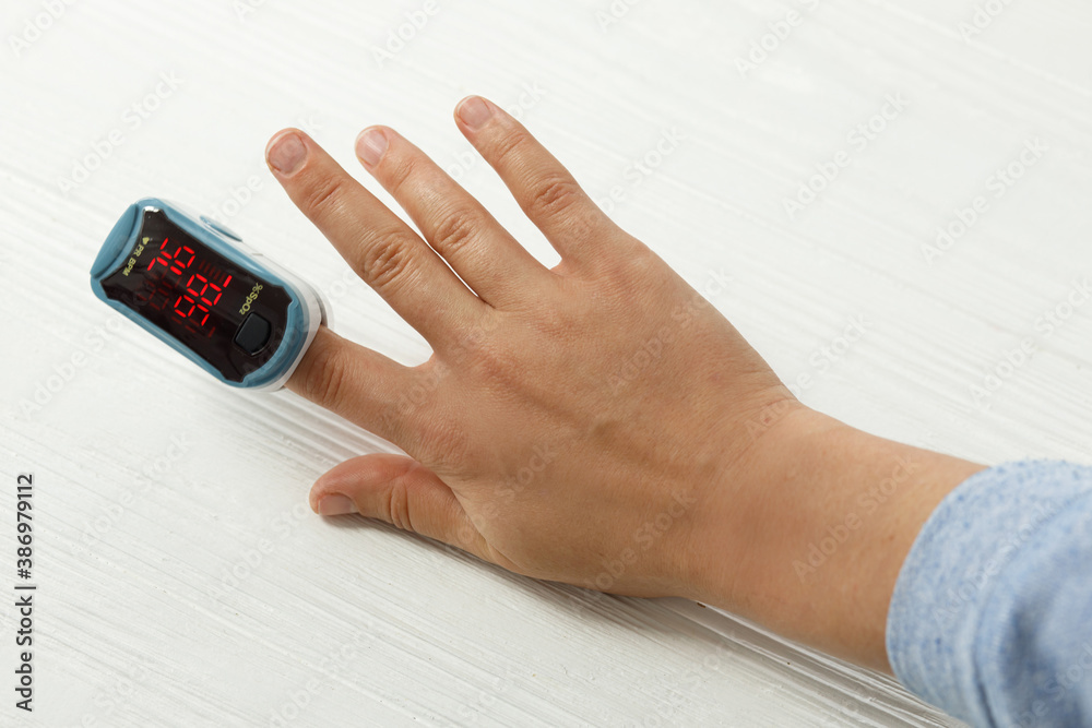 Pulse Oximeter on adult hand on white background, measuring blood ...