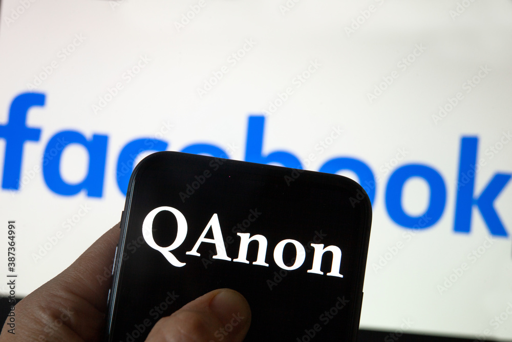 QAnon vs FACEBOOK. QAnon organization logo seen on the smartphone which ...