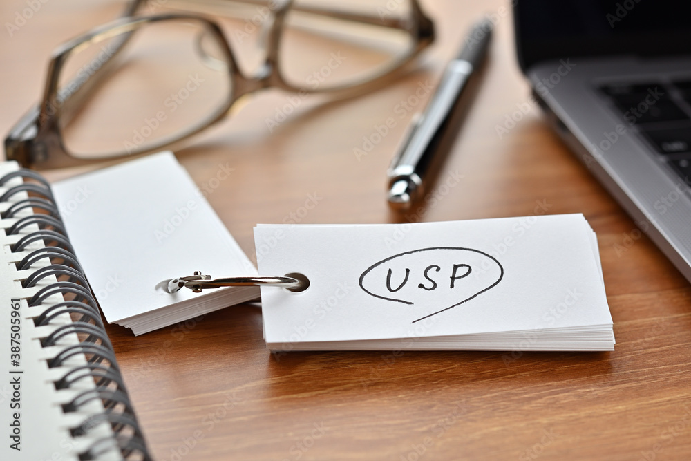 The words "USP" written in a word book with laptop PC and a pen. It is ...