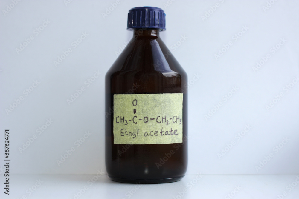 Ethyl acetate in a dark glass jar with a sticker and a chemical formula ...